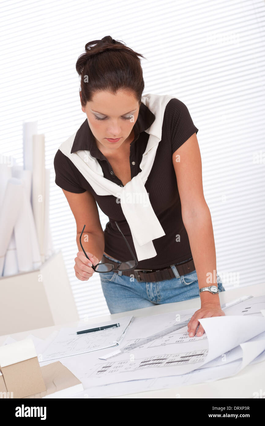 Young female architect reading plans Stock Photo - Alamy