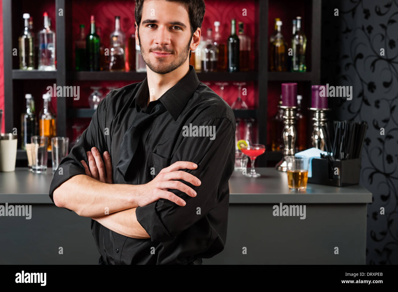 Barman in black standing at cocktail bar Stock Photo - Alamy