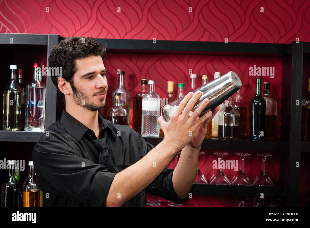 Young bartender make cocktail shaking drinks Stock Photo - Alamy