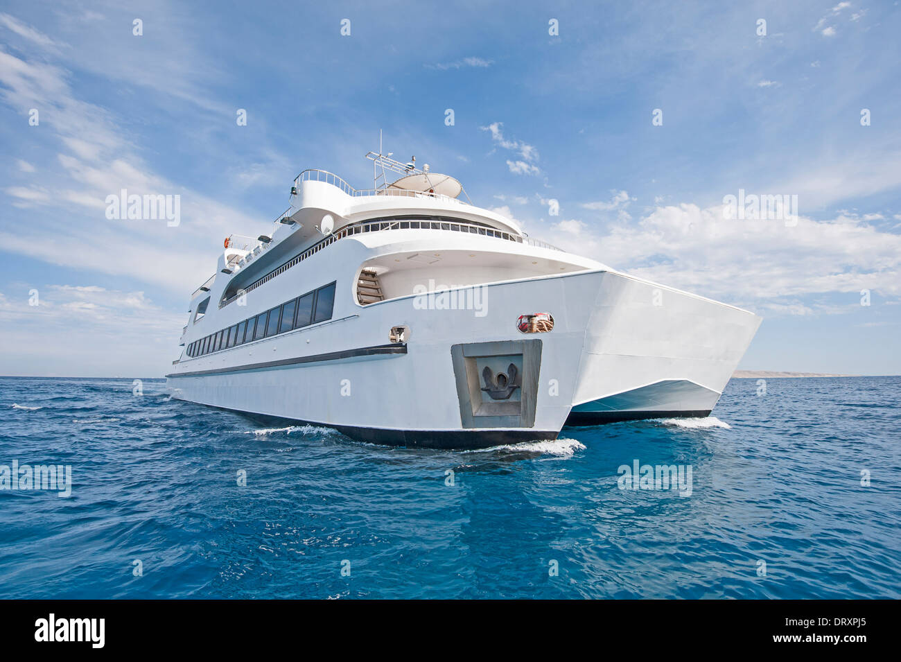 Large steel luxury private catamaran motor yacht sailing out at sea ...