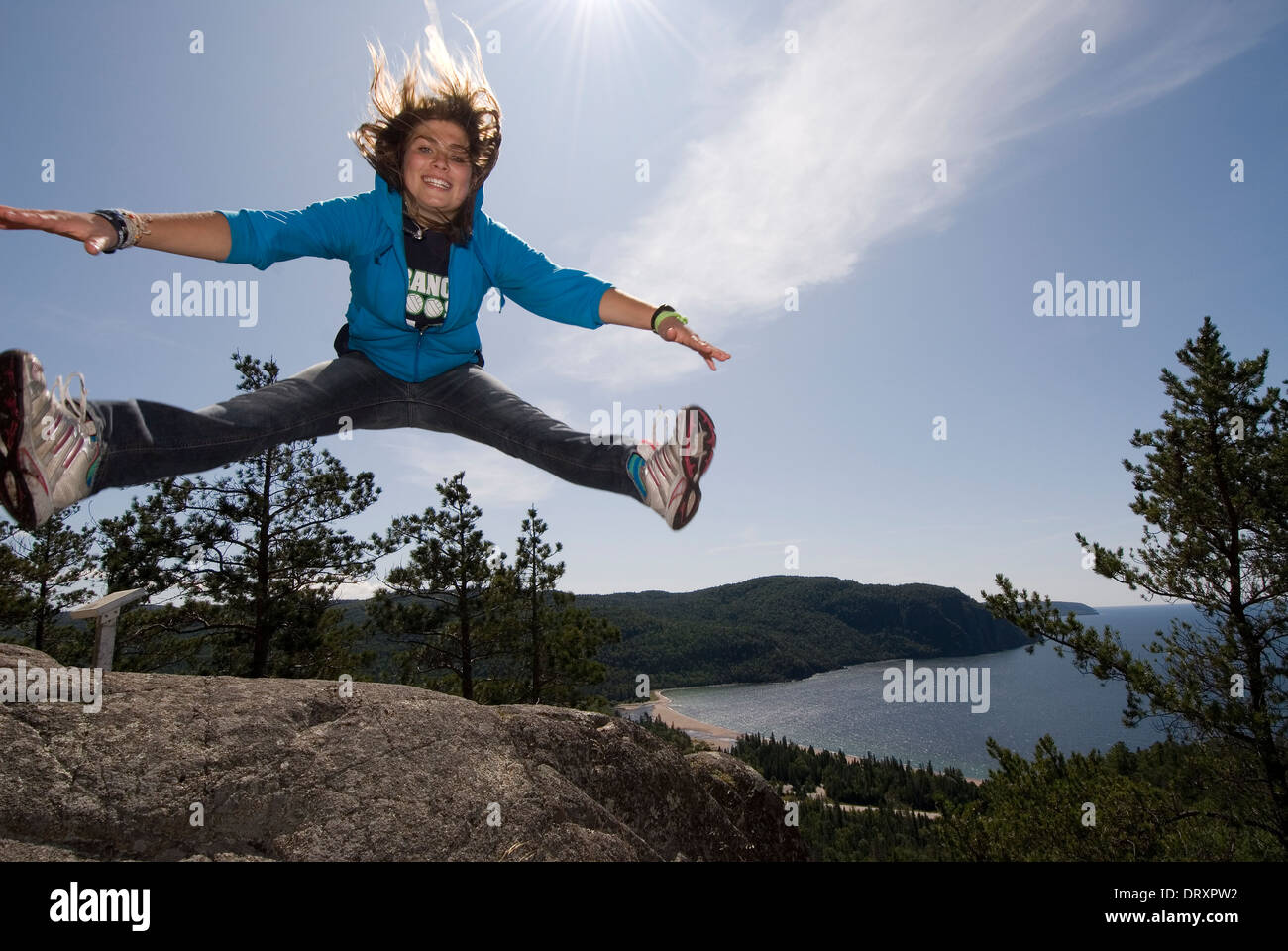 A young girl leaps off a rock at a scenic lookout Stock Photo - Alamy