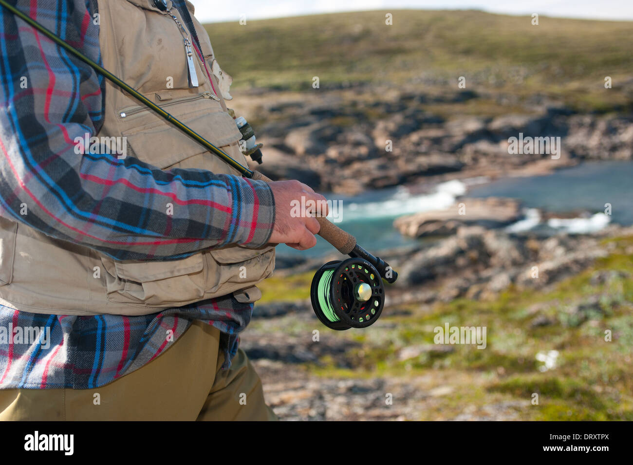 Angler walking along the shore after fly fishing in the arctic Stock ...