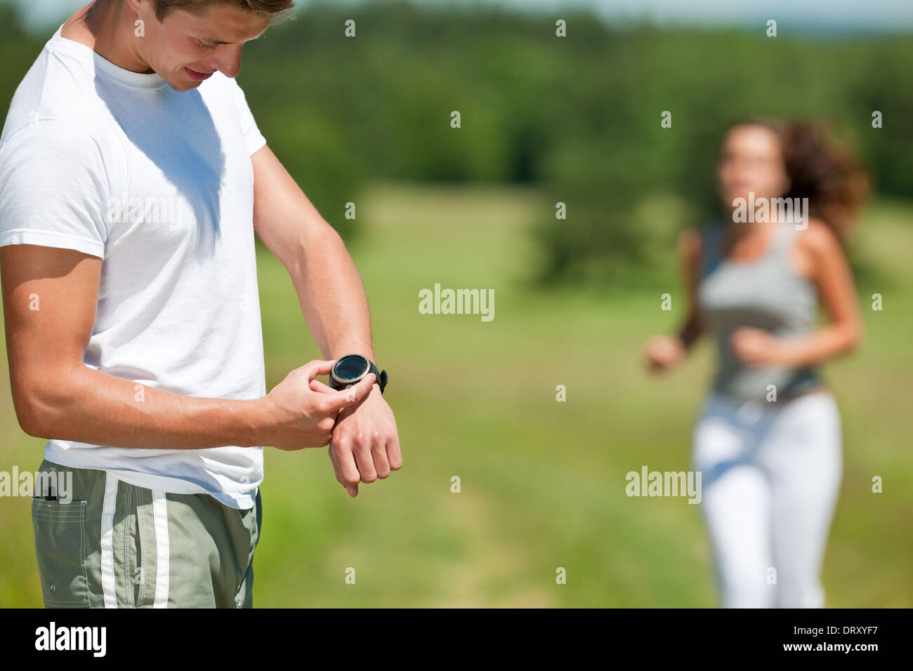Young man with stopwatch measuring time Stock Photo - Alamy