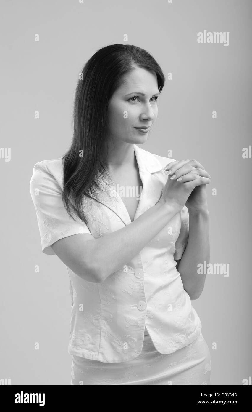 A pensive businesswoman is standing and hold her arms in lock. The ...