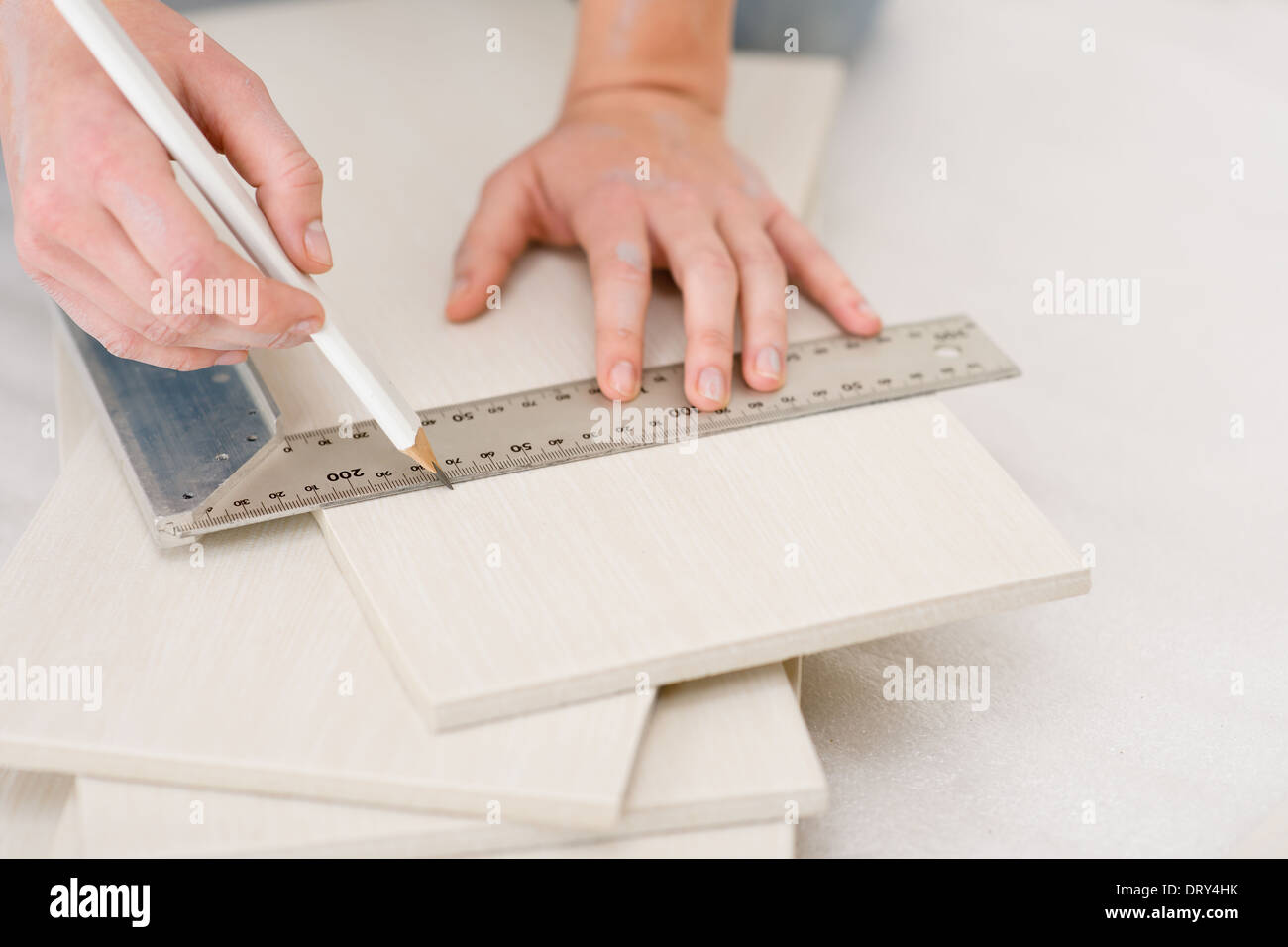 Home improvement - handywoman measuring tile Stock Photo - Alamy