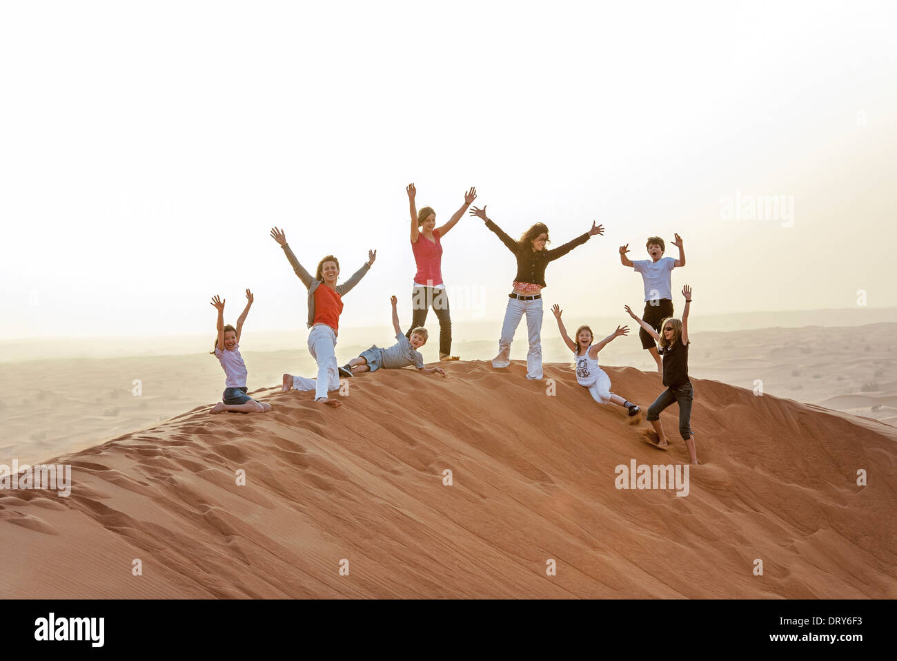 Girls playing on top of desert dune Stock Photo - Alamy