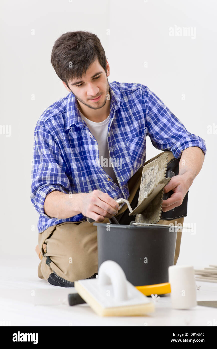 Home improvement - handyman laying tile Stock Photo - Alamy