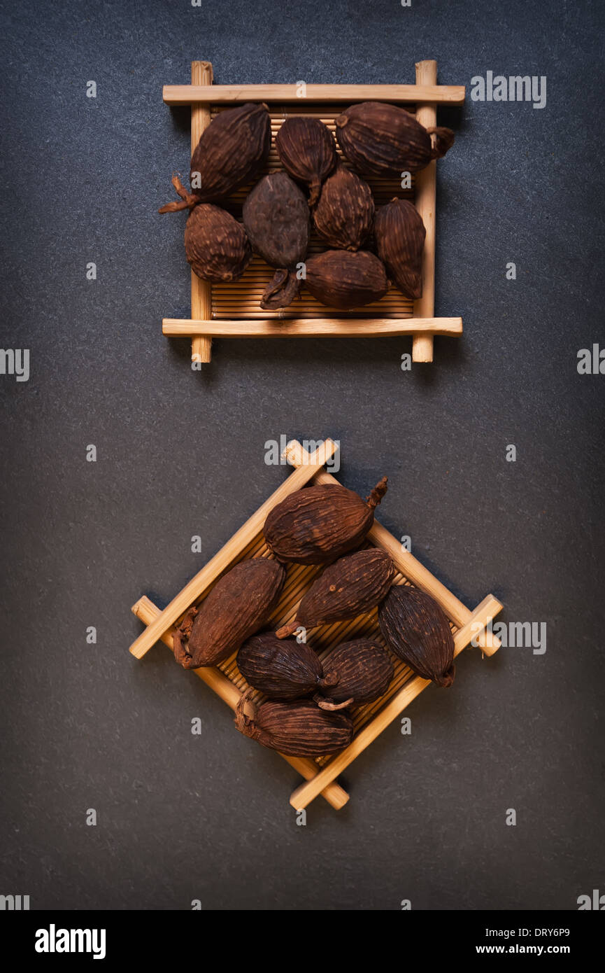 Chinese black cardamom on a black background Stock Photo - Alamy