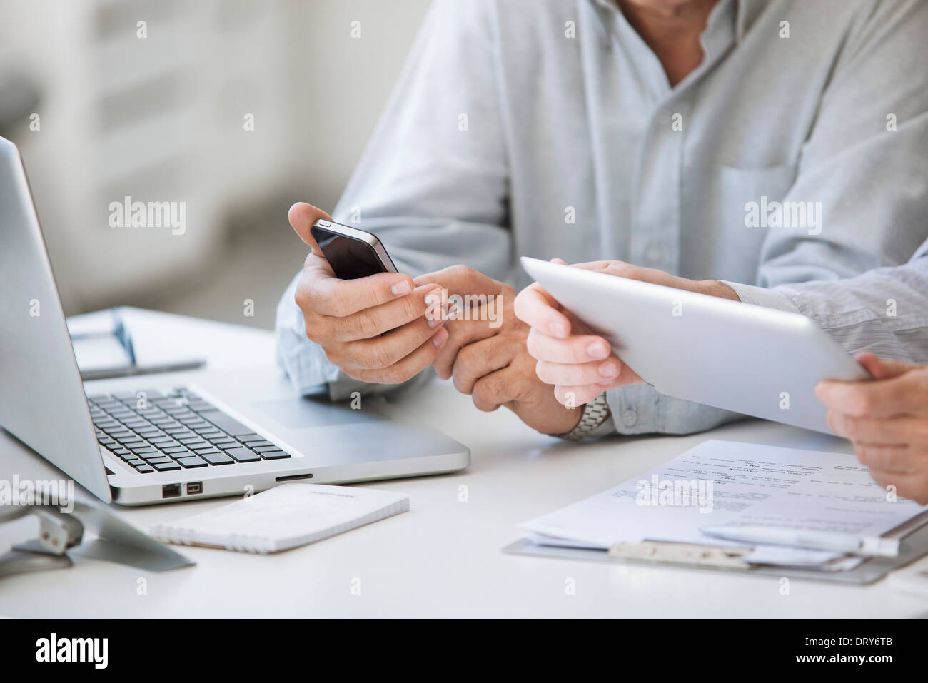 Men using wireless devices, cropped Stock Photo - Alamy