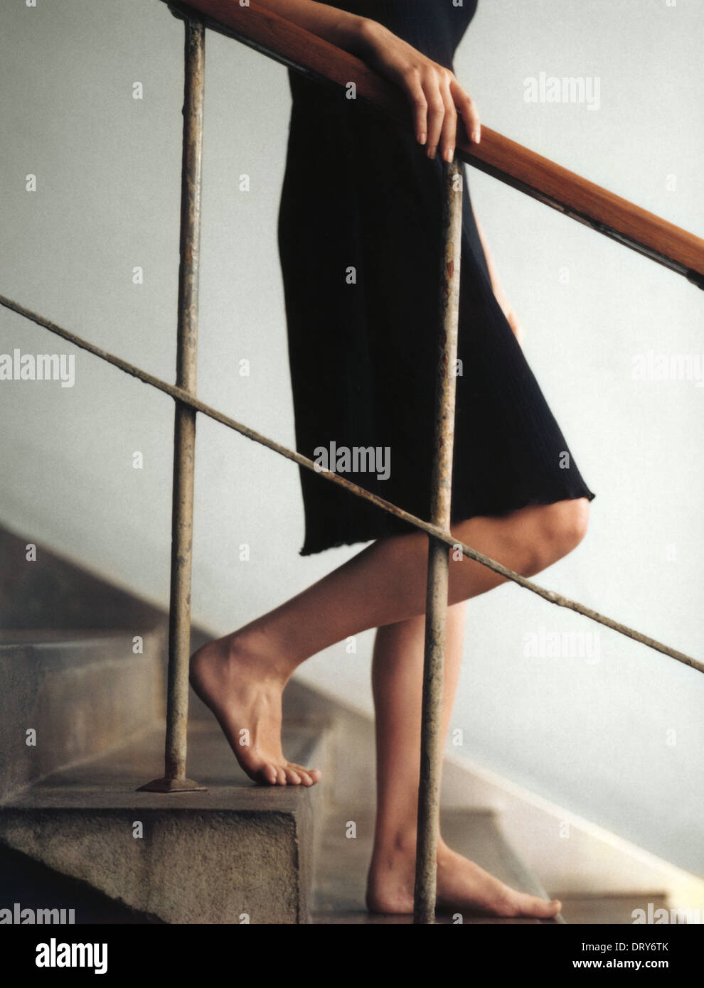 Woman walking downstairs barefoot, chest down Stock Photo - Alamy