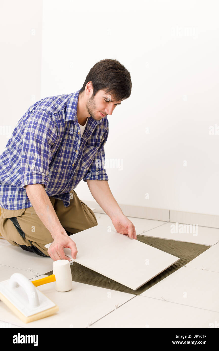 Home improvement - handyman laying tile Stock Photo - Alamy