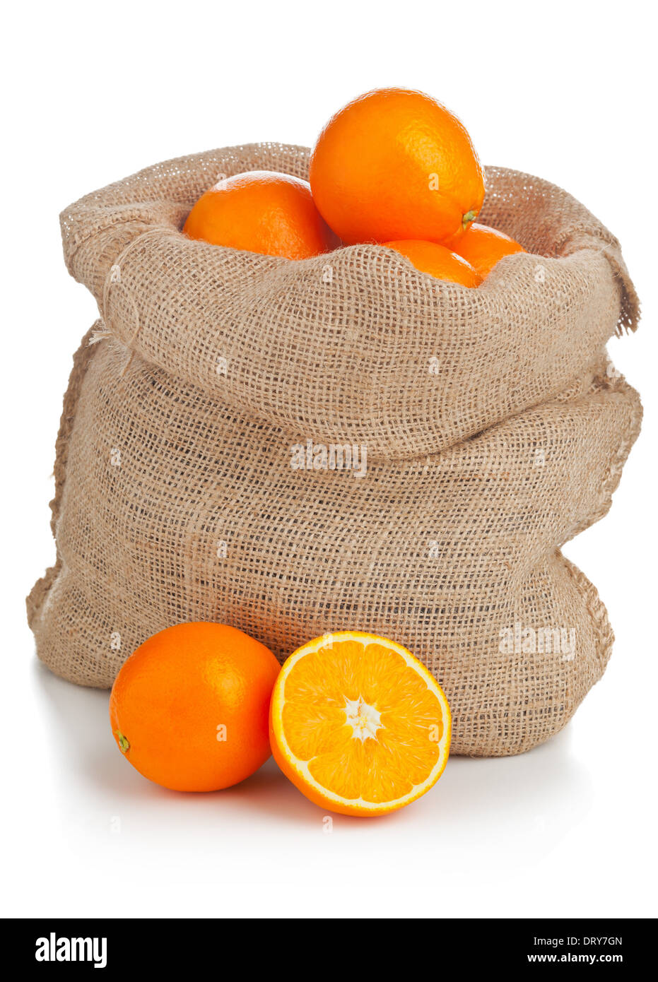 Whole and cut organic oranges in burlap sack over white background ...