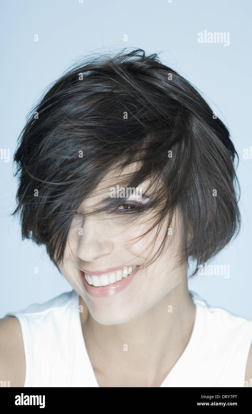 Woman smiling, hair covering one eye Stock Photo - Alamy