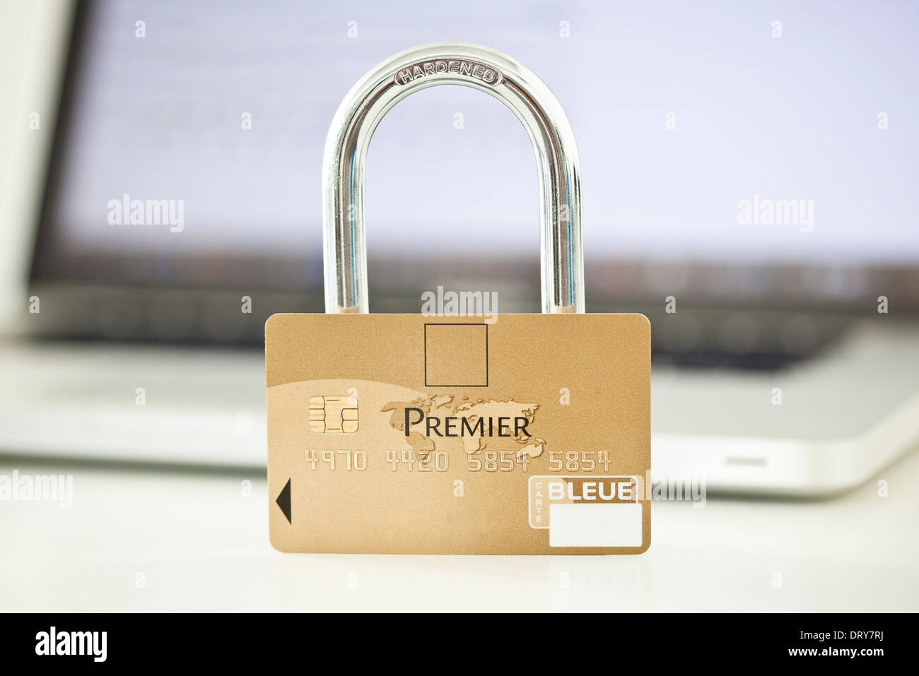 Credit card and lock resting on top of laptop computer representing ...