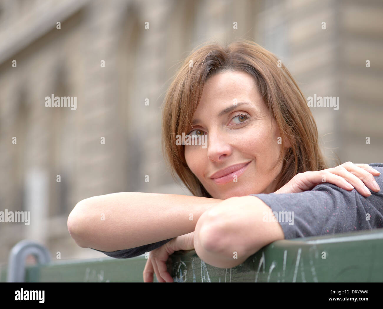 Woman leaning against railing, looking away in thought, portrait Stock ...