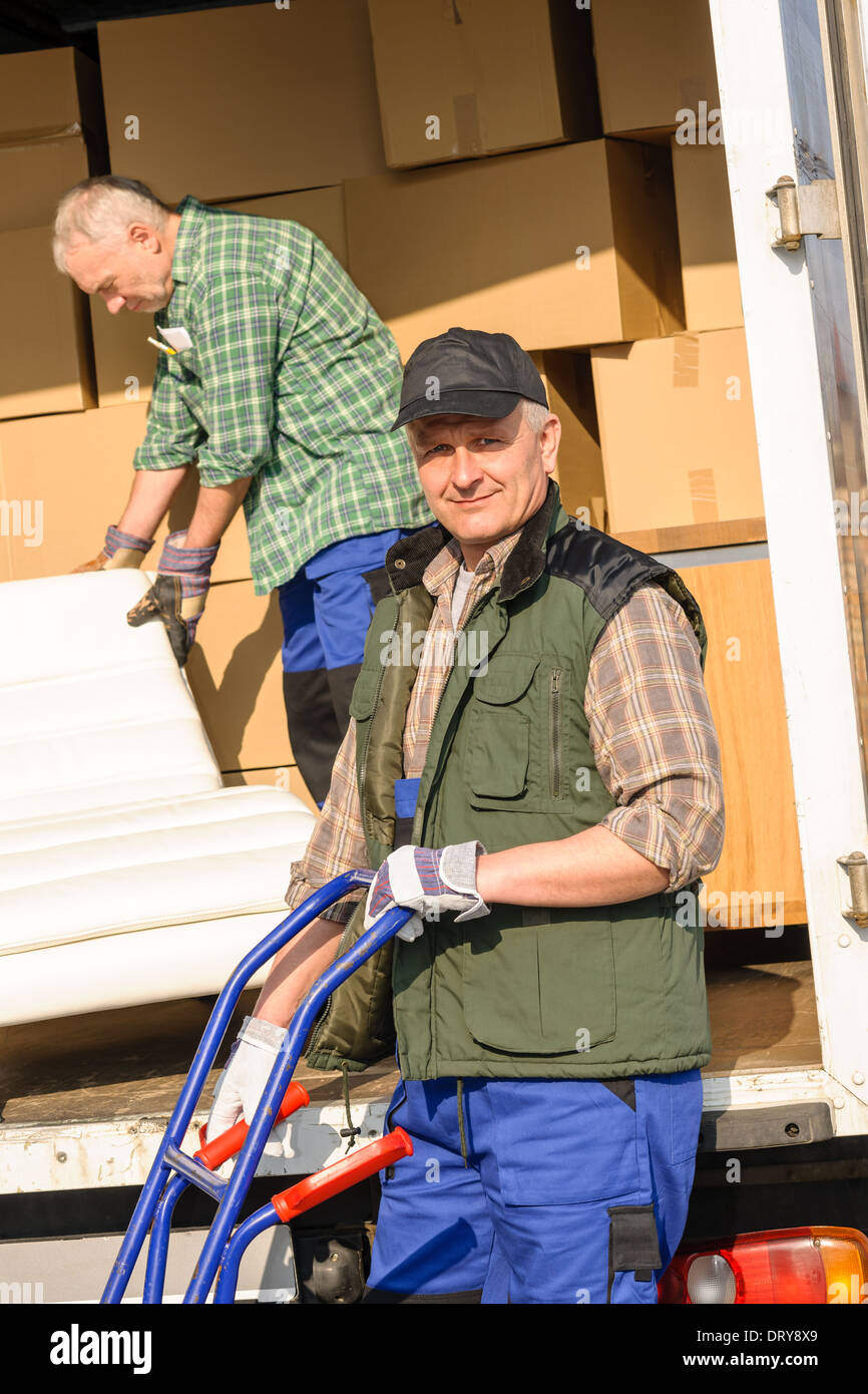 Mover two man loading furniture on truck Stock Photo - Alamy
