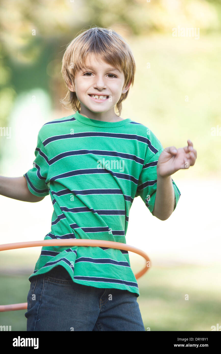 Boy playing with hula hoop in yard Stock Photo - Alamy