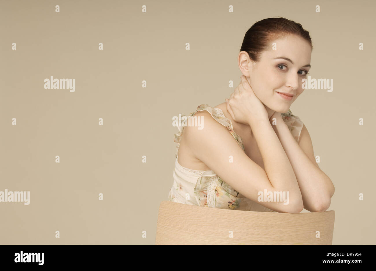 Woman wearing ruffly dress, hair in bun, smiling at camera, portrait ...