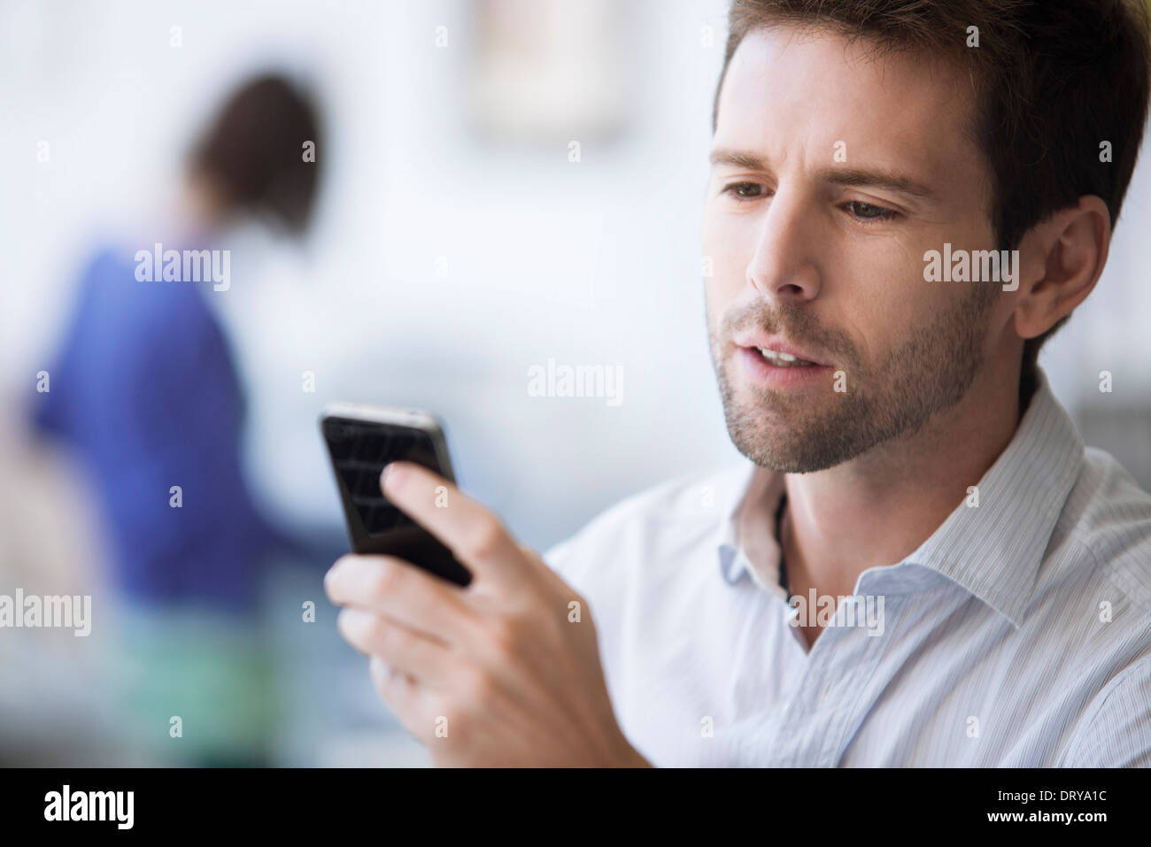 Mid-adult man checking cell phone Stock Photo - Alamy