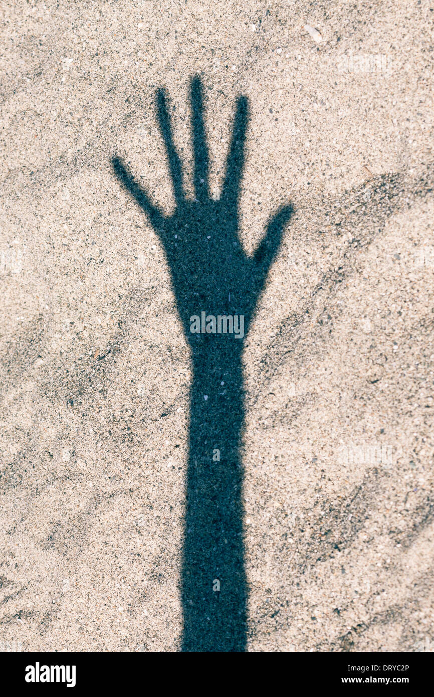 Shadow of hand over sand background Stock Photo - Alamy