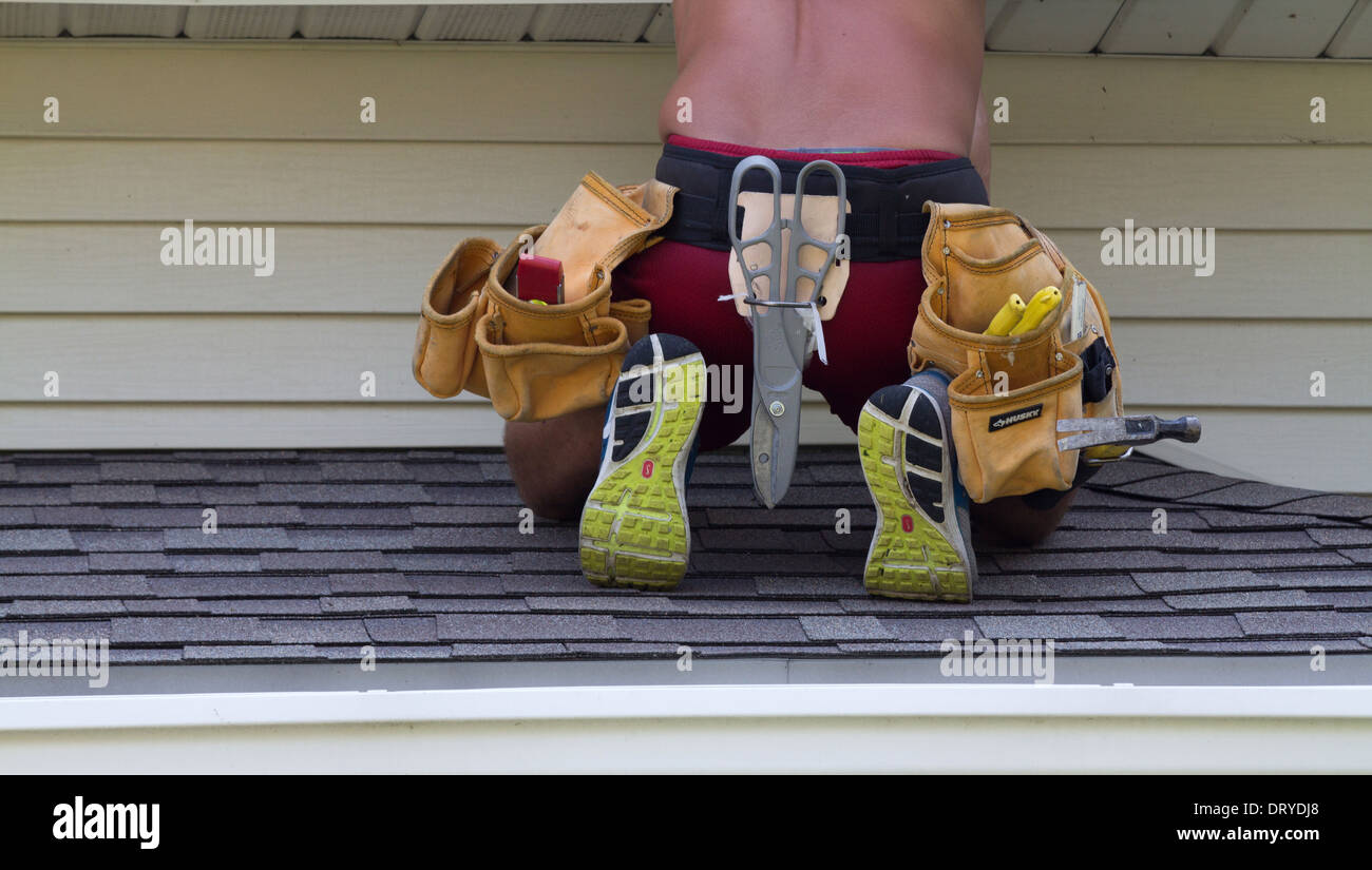 A construction worker instalating house roof rain gutter close up of ...