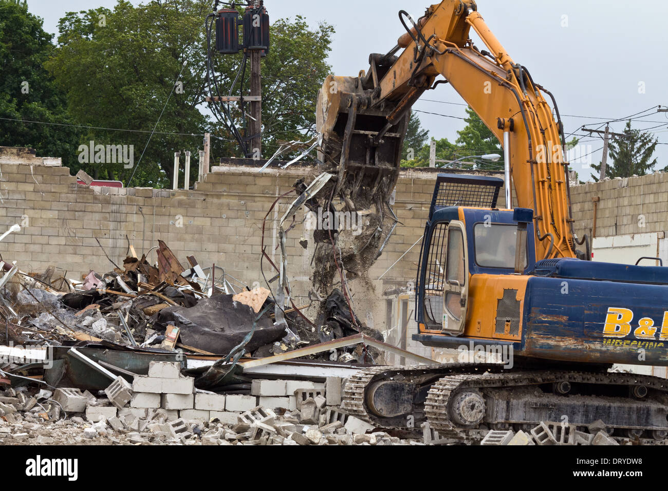 Excavator driver working on construction site digger demolishing ...