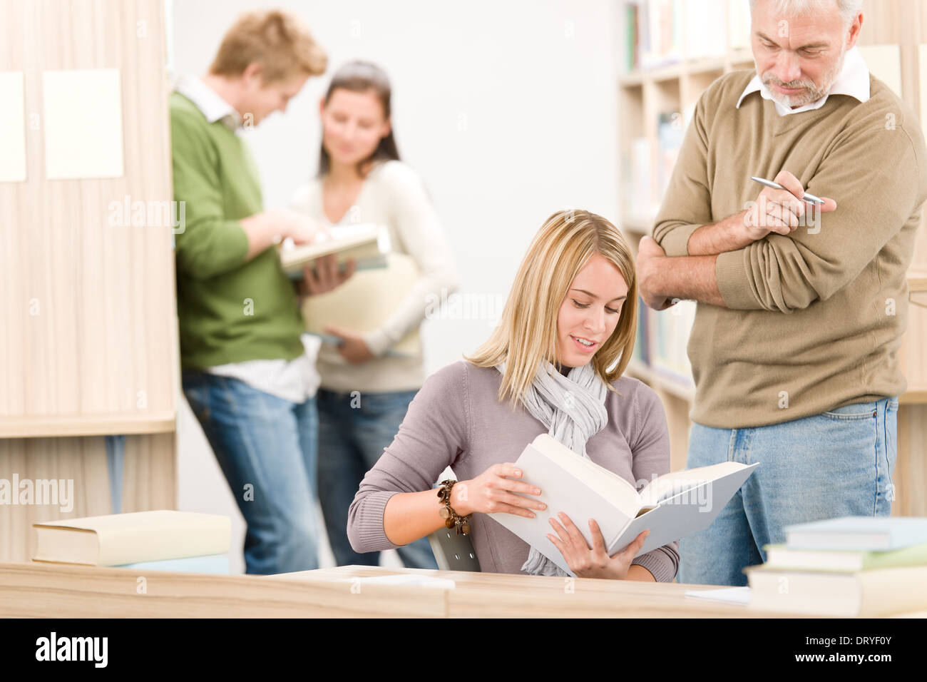 High school library - student with professor Stock Photo - Alamy