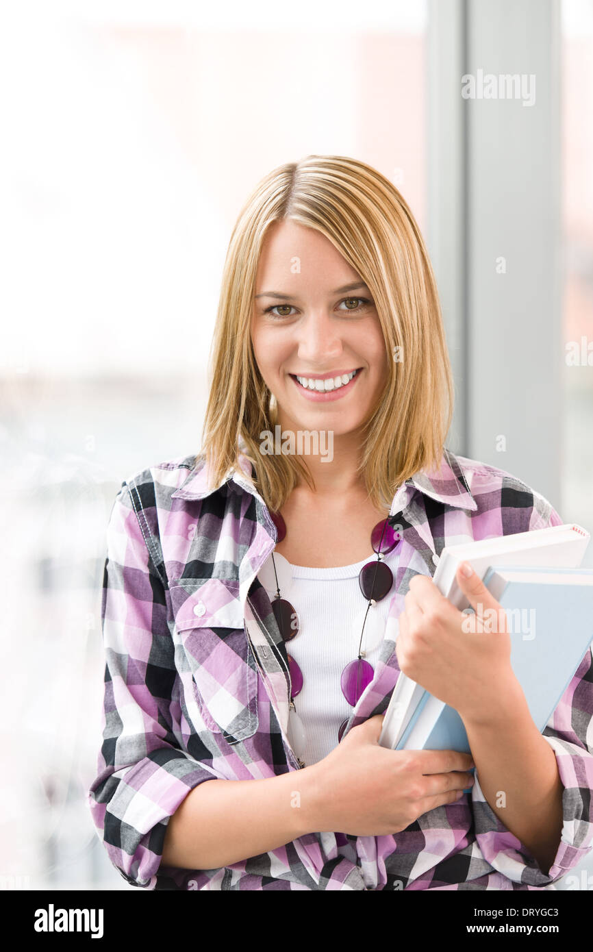 Happy young woman holding books Stock Photo - Alamy