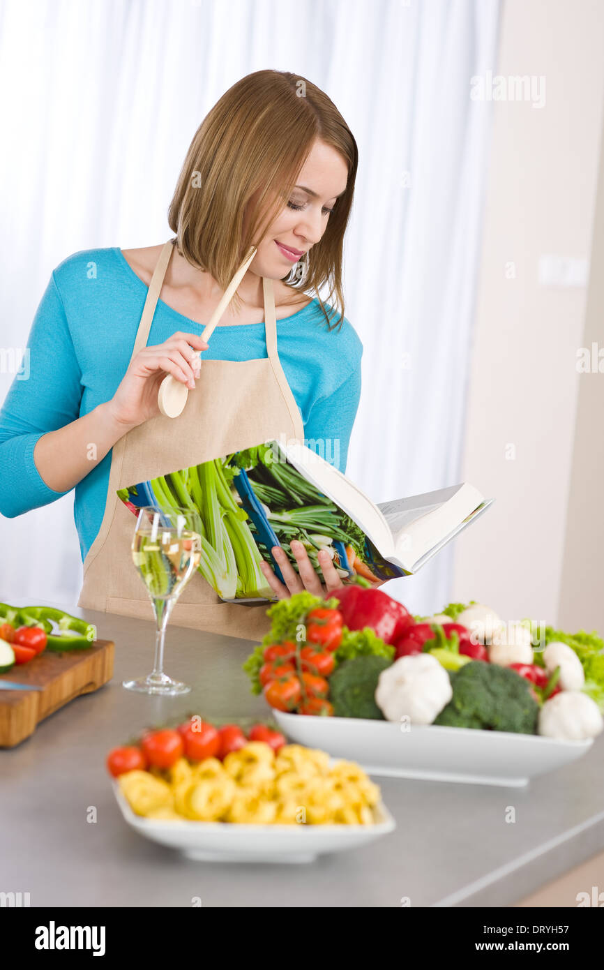 Cooking - Woman reading cookbook in kitchen Stock Photo - Alamy