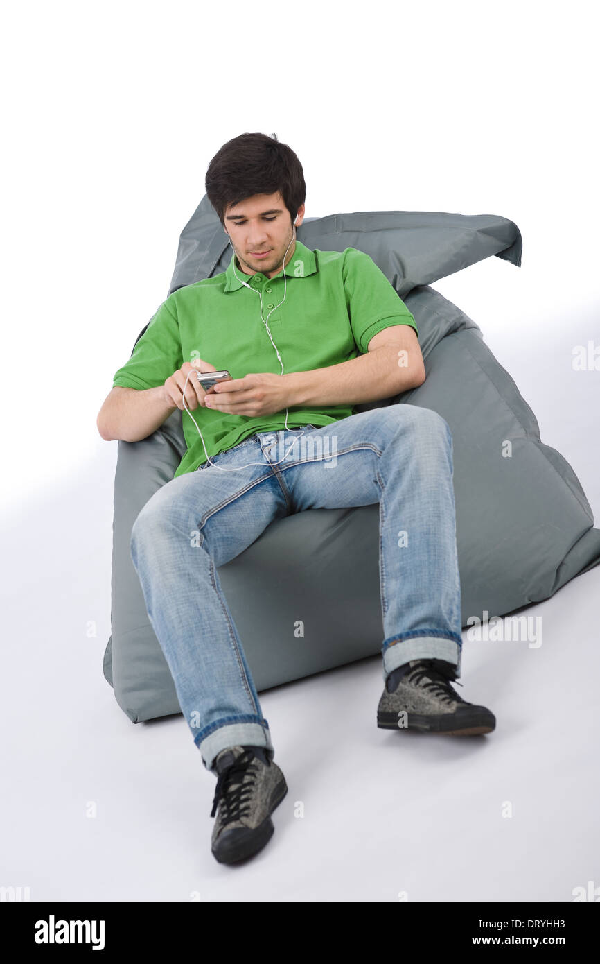 Young man with ear buds listening to music Stock Photo - Alamy