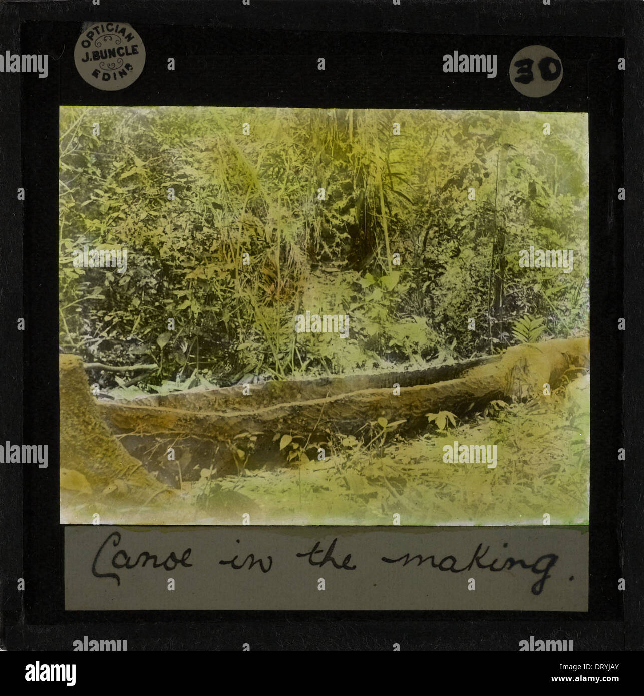 A photograph depicting the process of crafting a canoe in the late 19th ...