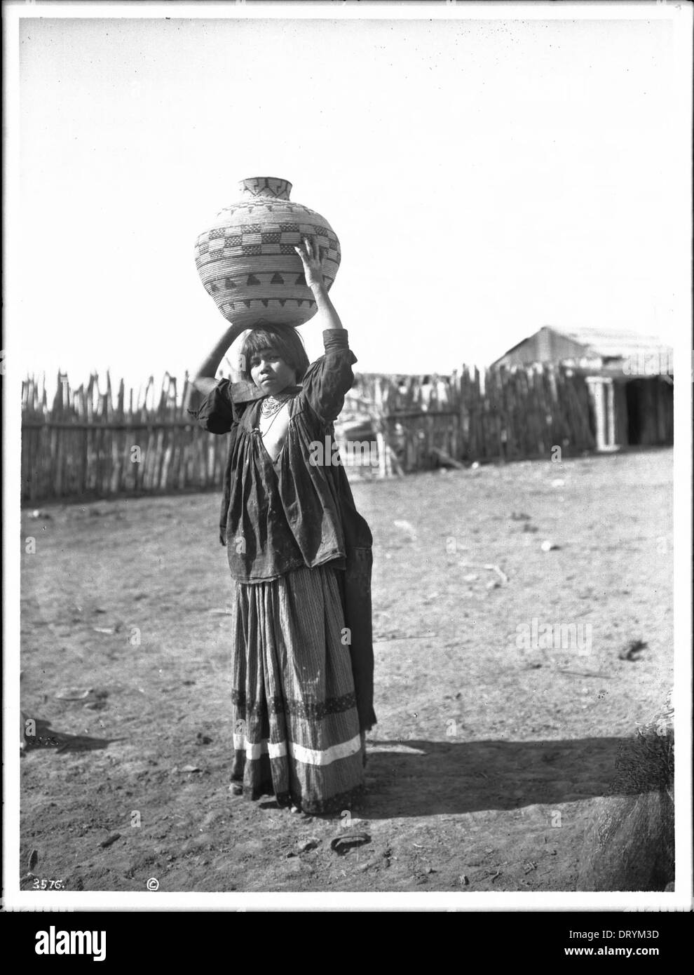 An Apache Indian maiden is shown carrying an olla (water jar) on her ...