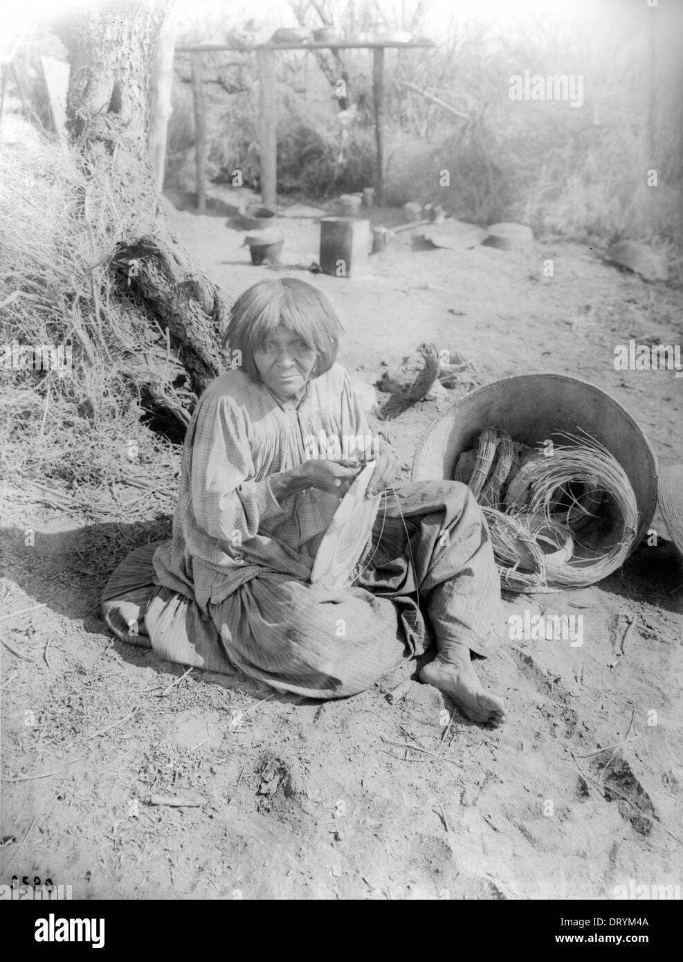 A photograph from around 1900 showing an Apache Indian woman weaving ...