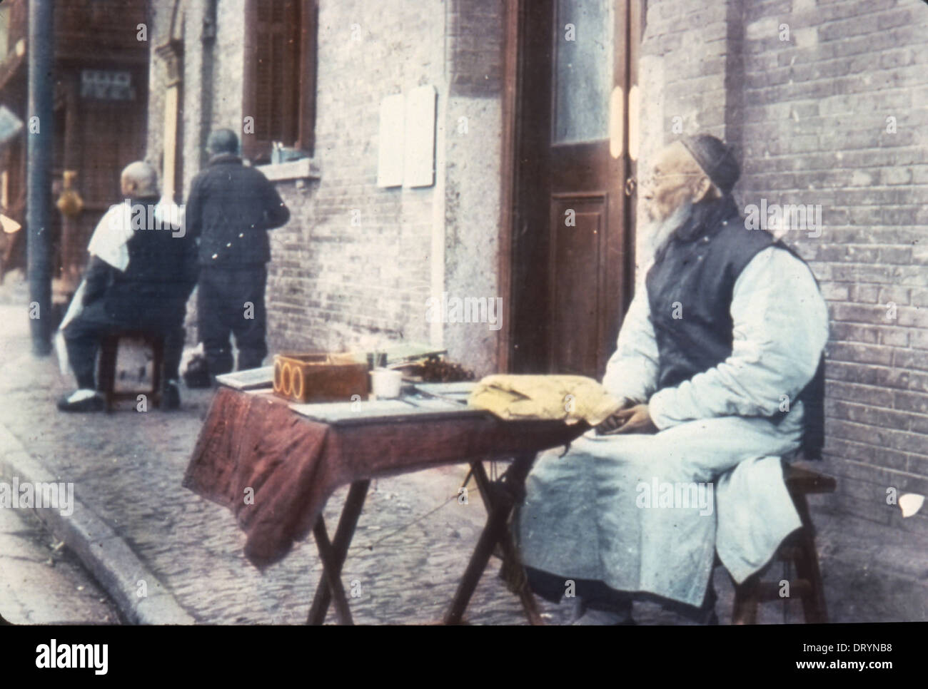 A street scene in Shanghai during 1900-1919, featuring a man working as ...