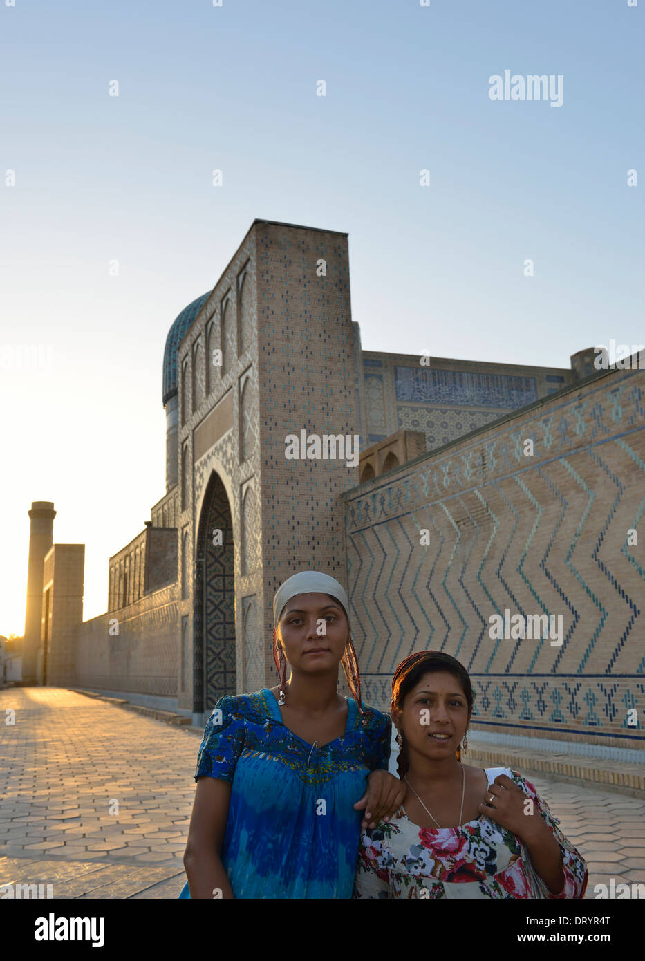 Two local women posing with Bibi-Khanym Mosque in the background at ...