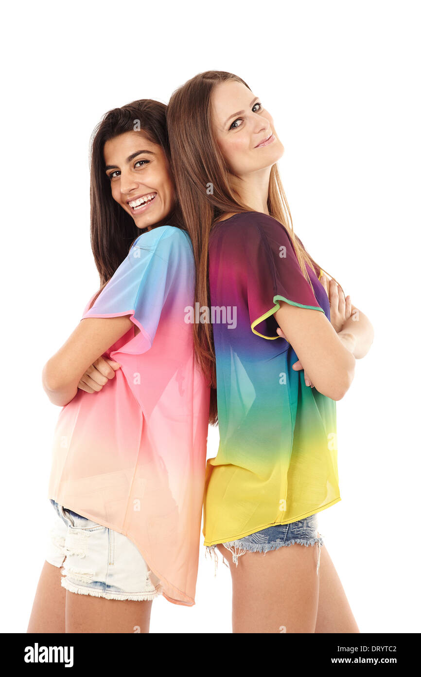 Portrait of girlfriends standing back in back with arms folded and ...