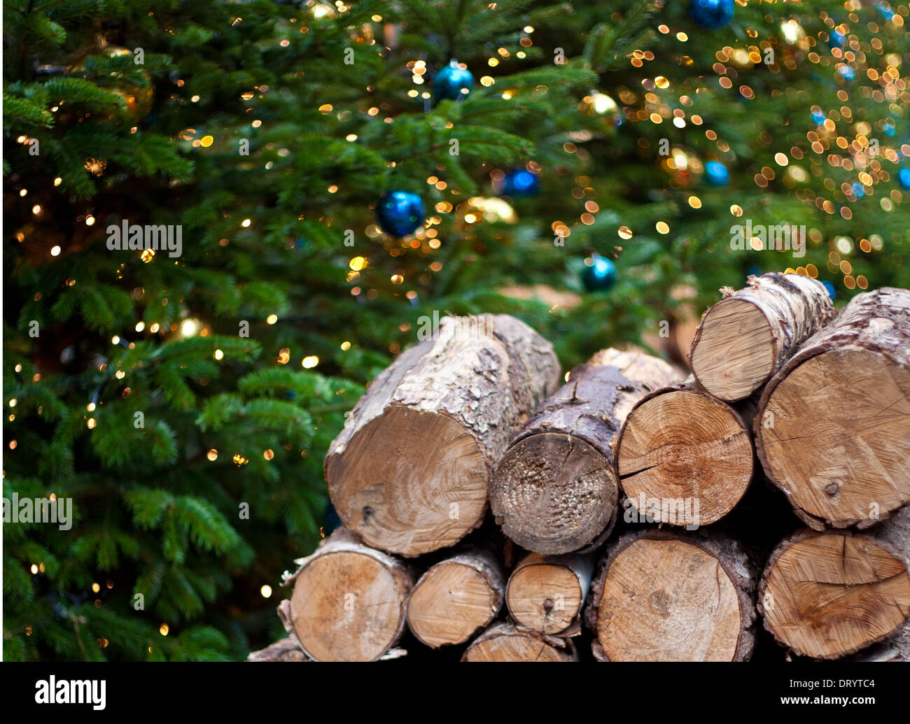 Log pile in front of christmas tree decoration Stock Photo - Alamy