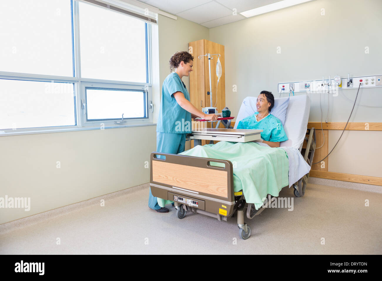 Nurse Bringing Breakfast For Male Patient In Hospital Stock Photo - Alamy