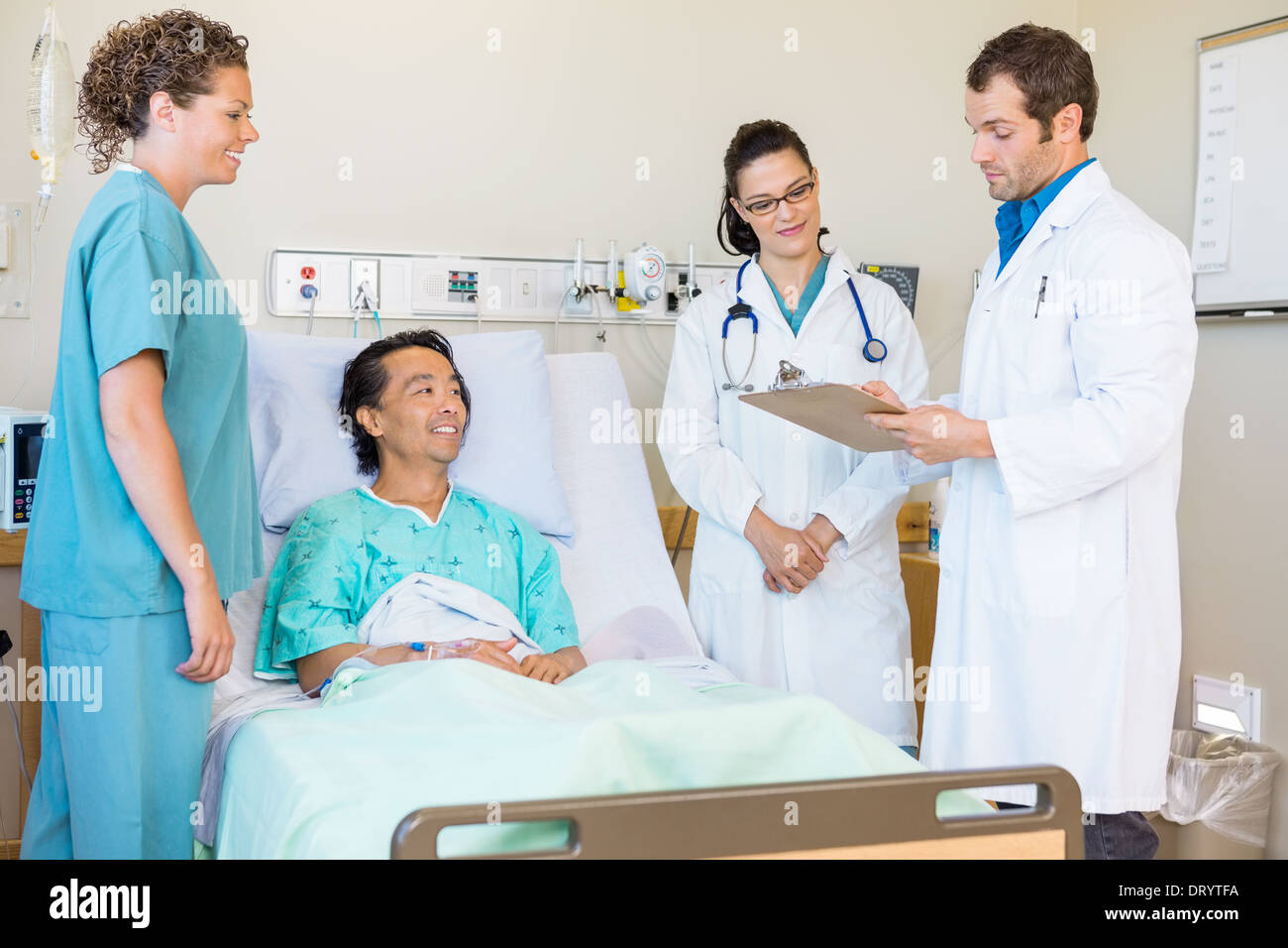 Doctors Discussing Notes While Nurse And Patient Looking At Them Stock ...