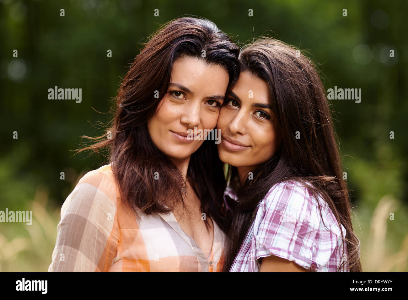 Closeup Of Mother And Daughter Staying Cheek To Cheek In A Forest Stock