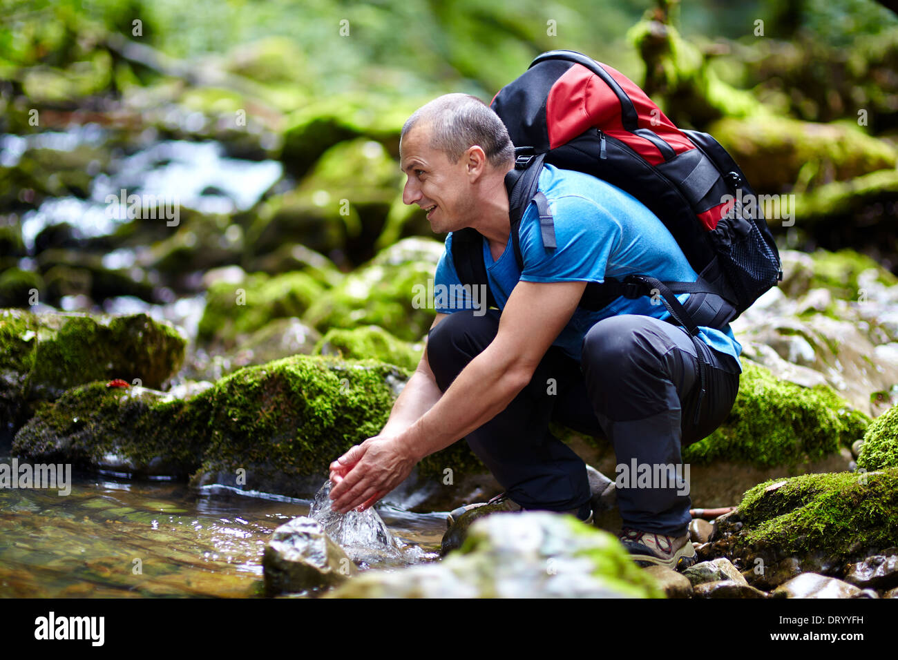 Tourist washing hands in a mountain river Stock Photo - Alamy