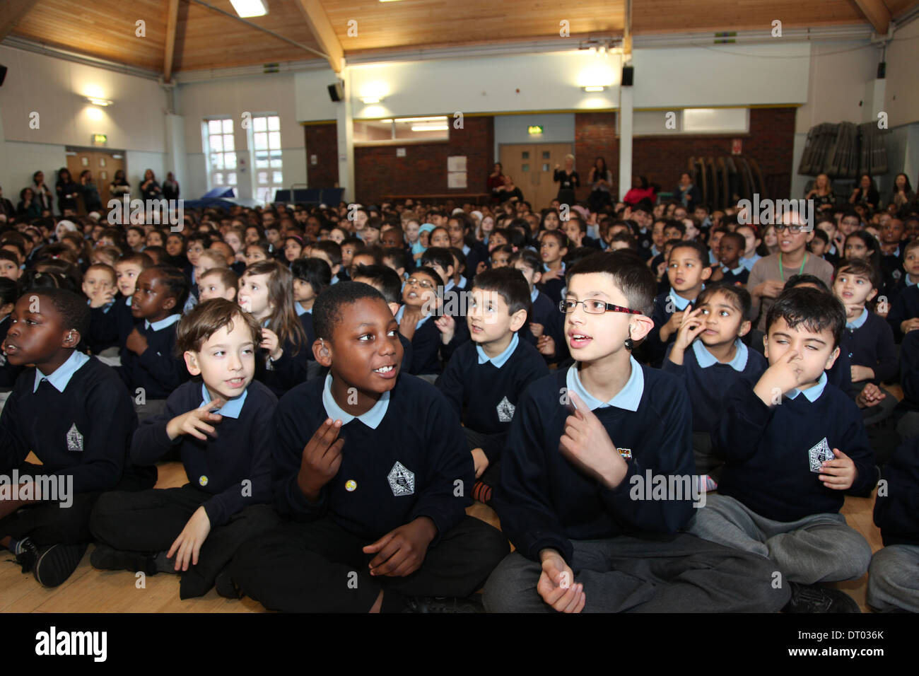 Children singing and performing sign language at a school assembly ...