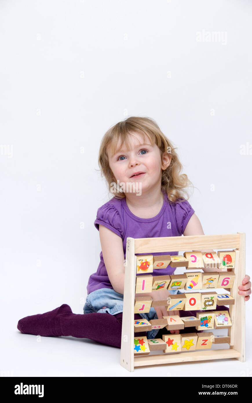 Little Girl learning her alphabet with a wooden spinning letters toy ...