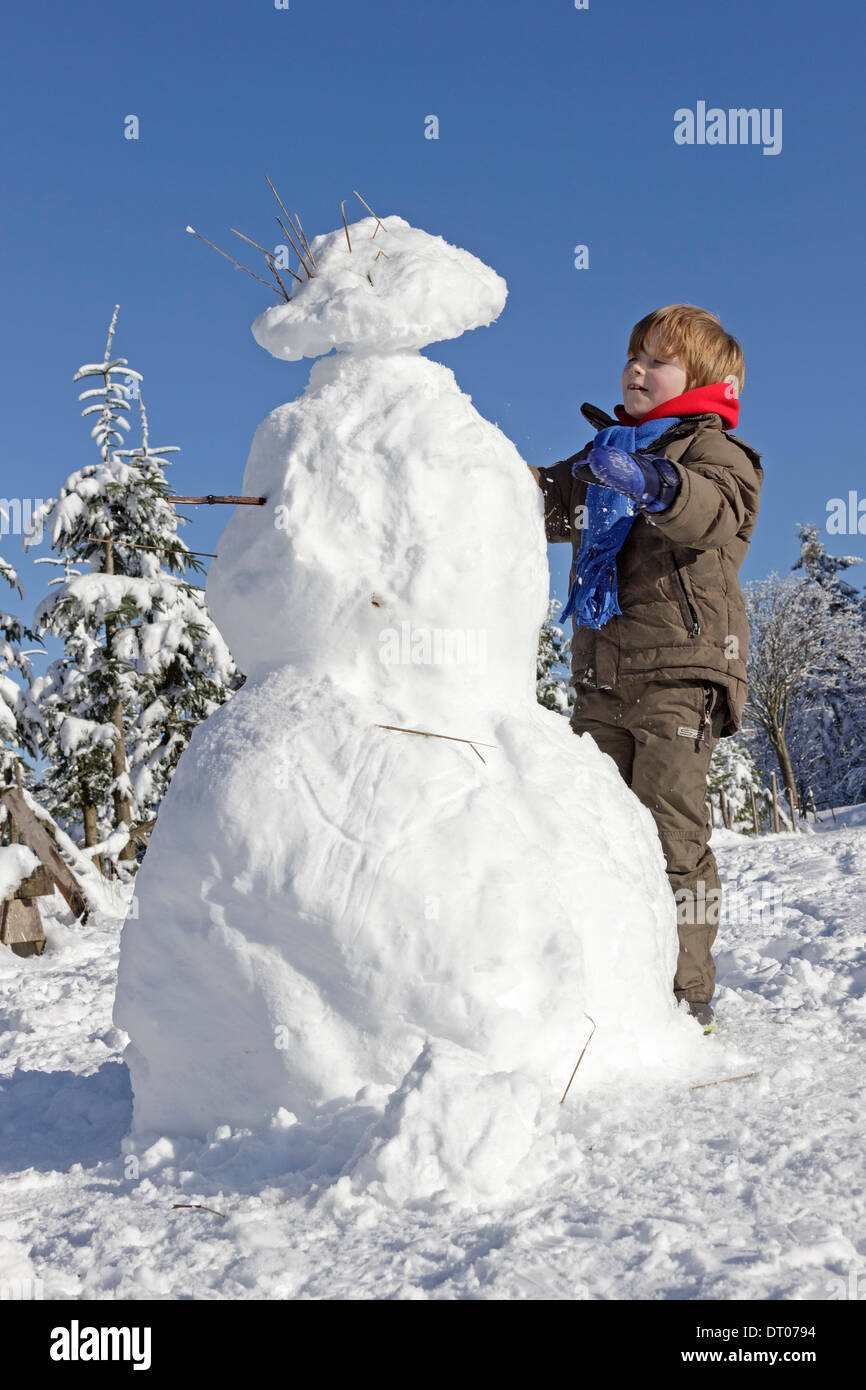 young boy building a snowman on Kahler Asten near Winterberg, Sauerland ...