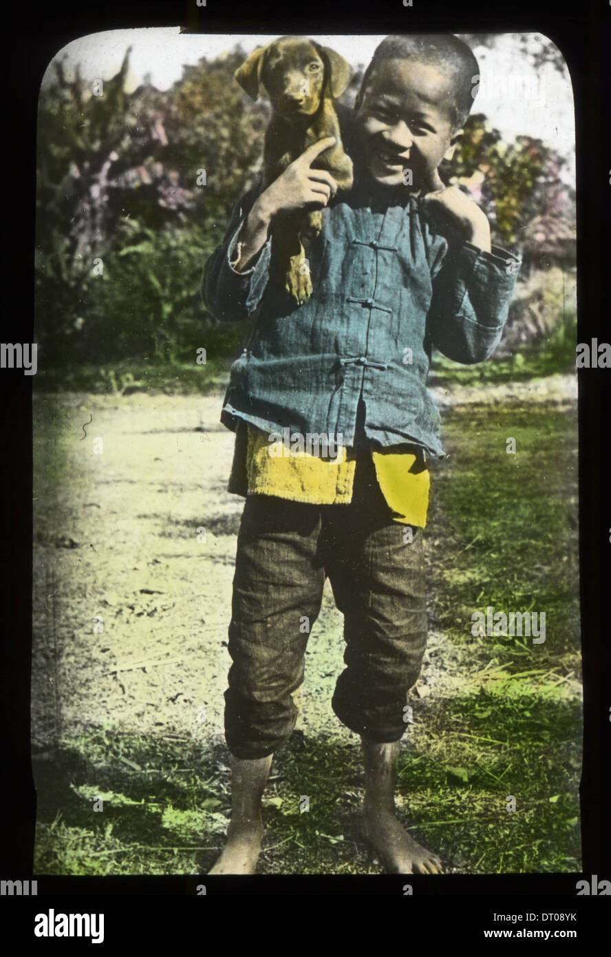 A photograph of a child carrying a dog in China, taken between 1918 and ...