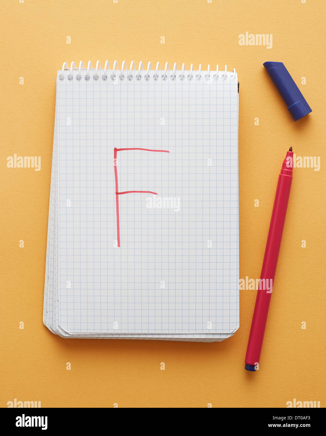 F letter handwritten in notebook page on yellow background alphabet ...