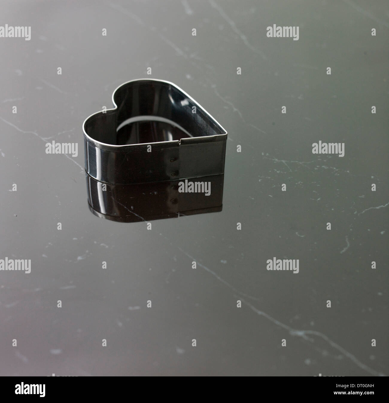 Heart shaped, metal pastry cutter, on a Grey reflective surface Stock ...