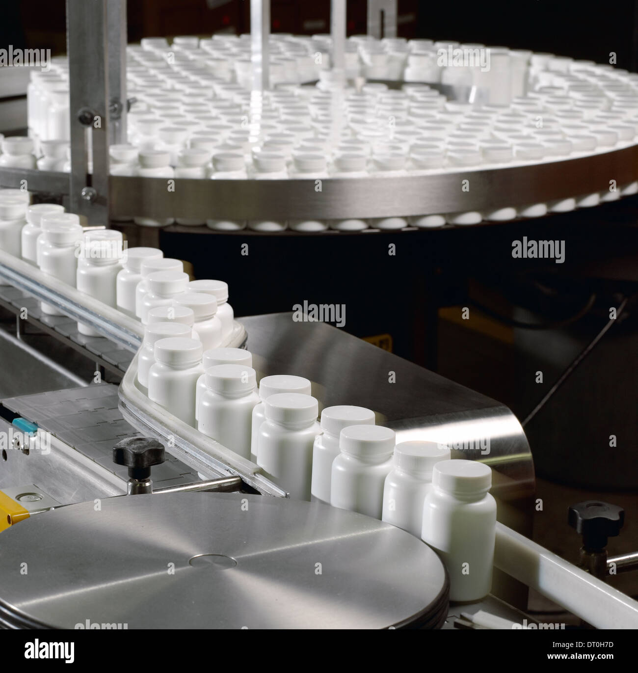 Bottles preparing to be labeled in a pharmaceutical processing facility ...