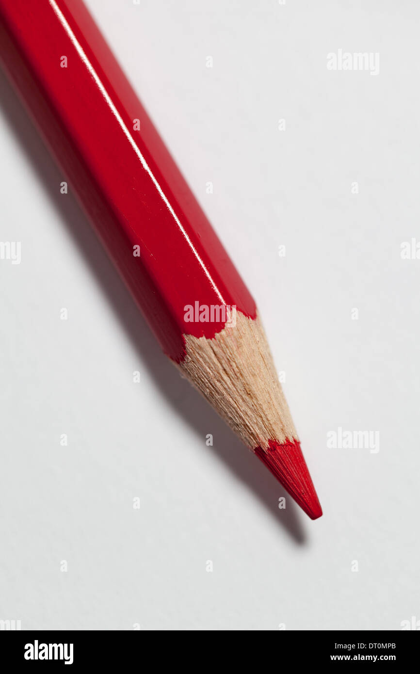 A red coloured pencil on a white paper background Stock Photo - Alamy