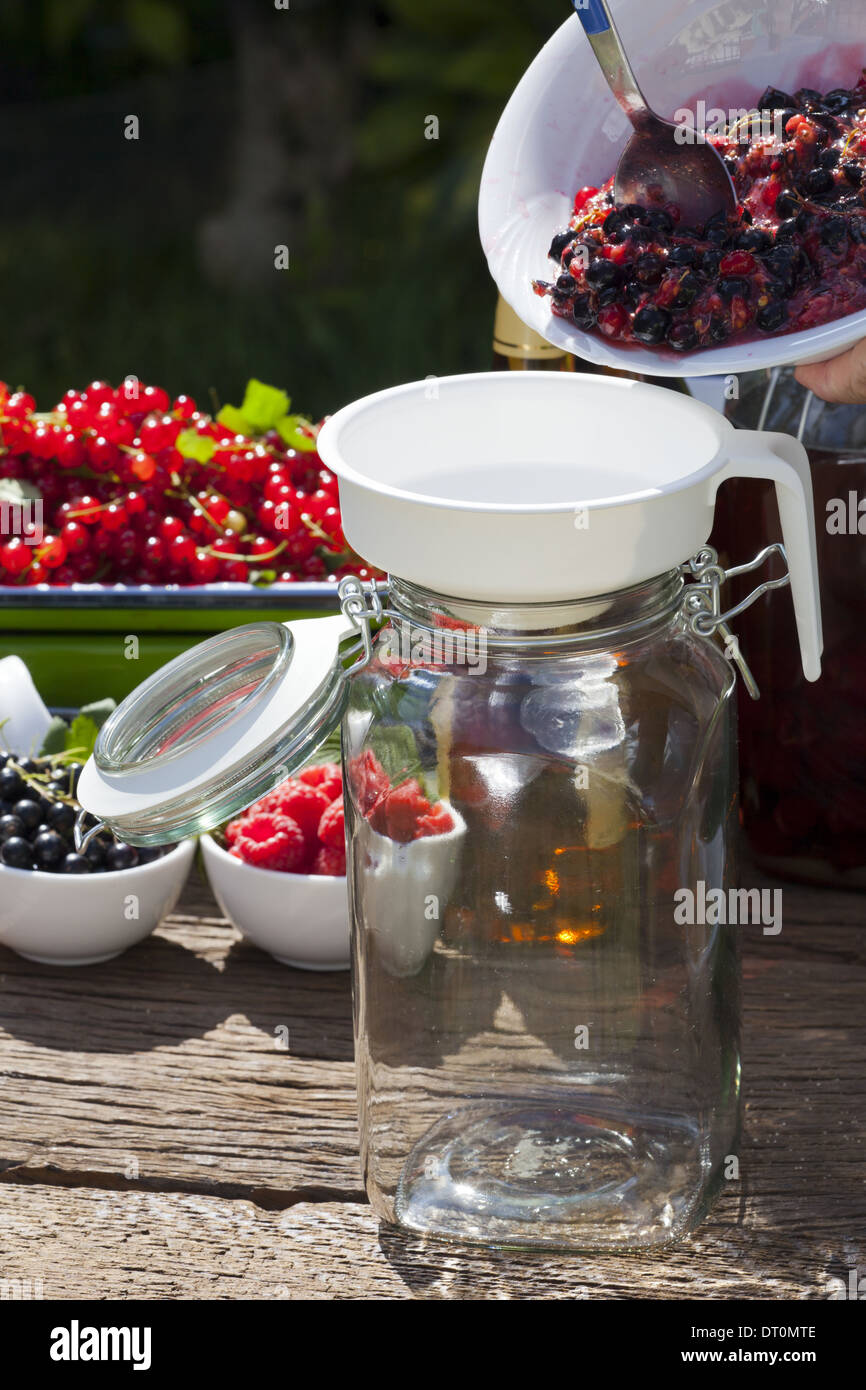 Pour in mashed fruit with a funnel into a large canning jar Stock Photo ...